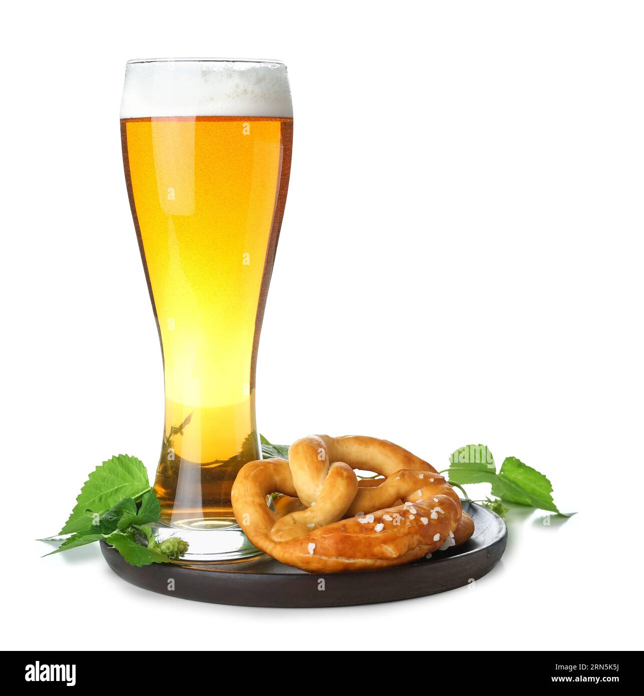 Plate with glass od cold beer and tasty pretzel on white background ...