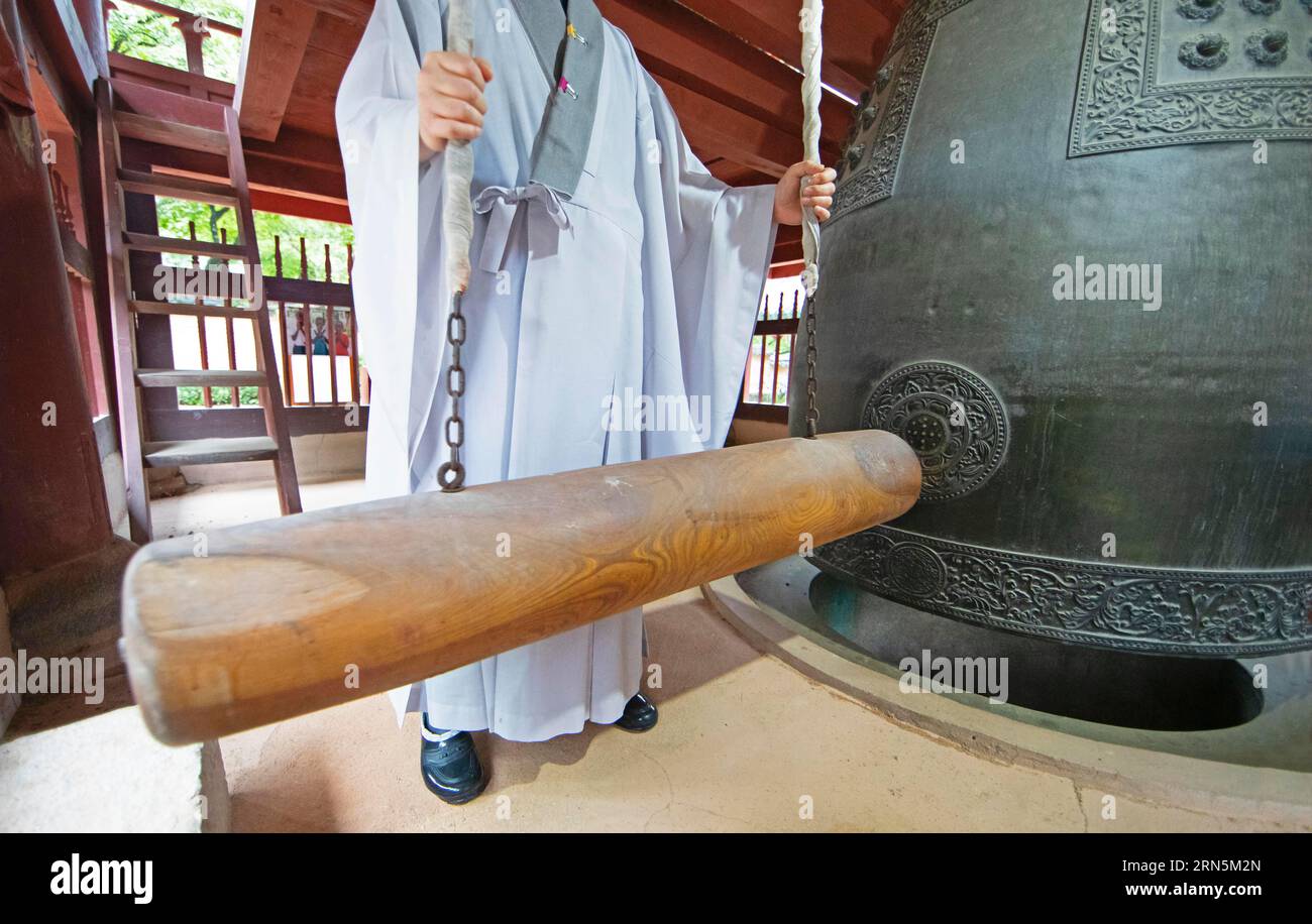 Man strikes temple bell hi-res stock photography and images - Alamy