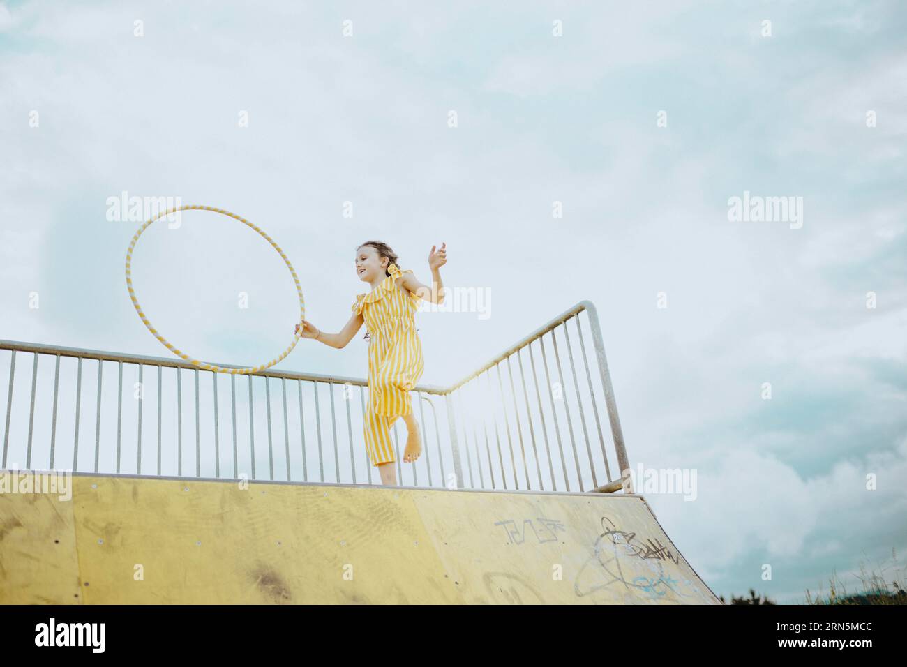 Girl, 9 years, in yellow and white striped jumpsuit gymnastics with ...