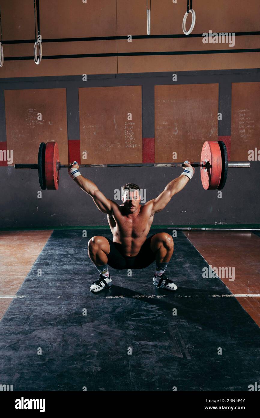 Gym concept with strong man lifting barbell Stock Photo - Alamy