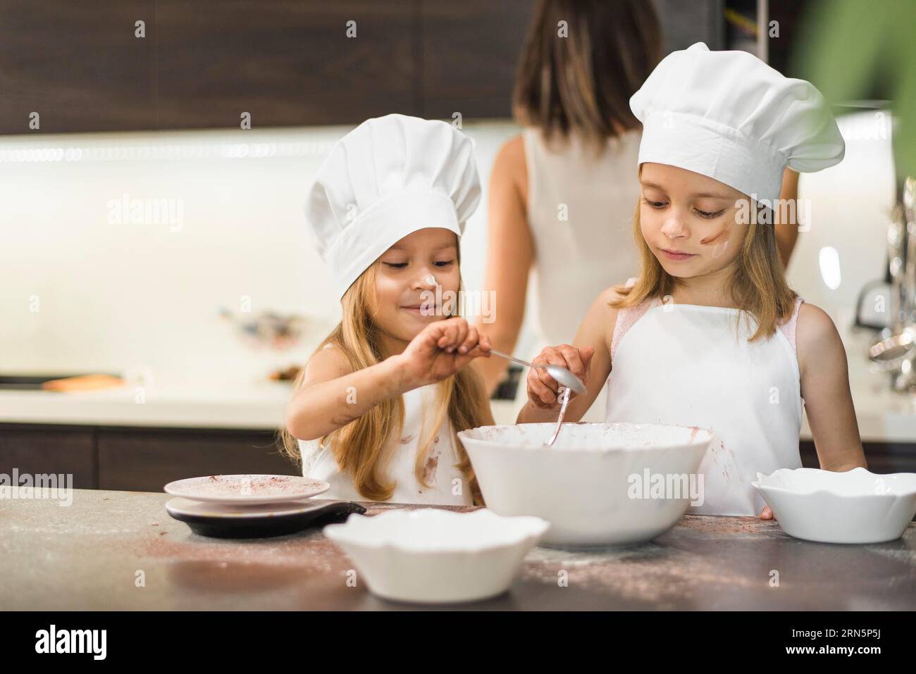 Little siblings chef hat mixing ingredients bowl kitchen worktop Stock ...