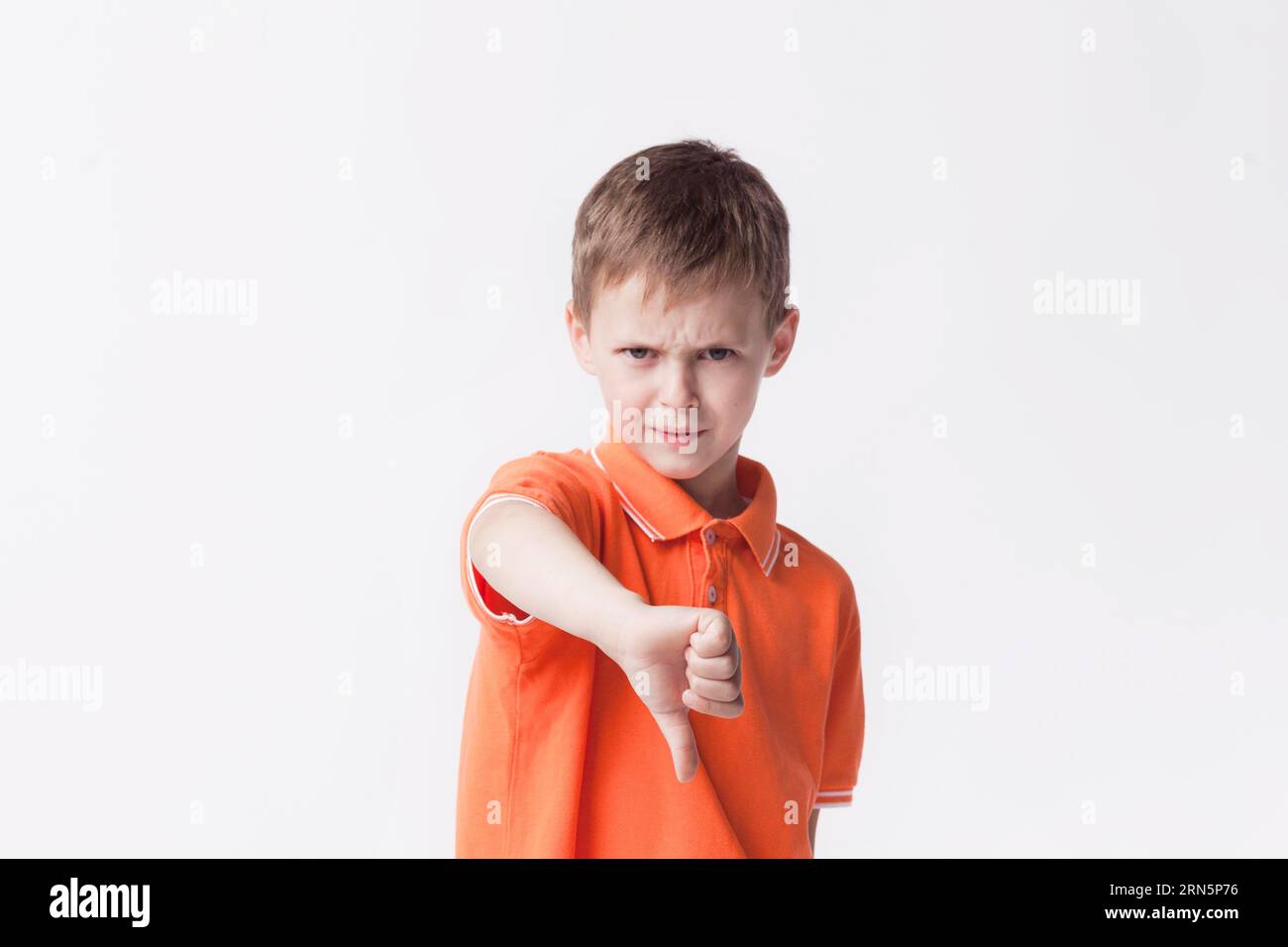 Angry little boy showing dislike gesture white backdrop Stock Photo - Alamy