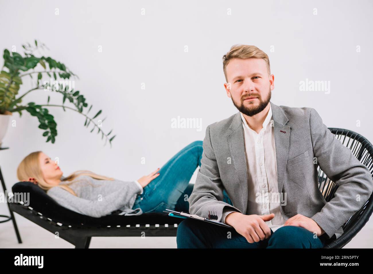 Confident male psychologist sitting chair front her female patient ...