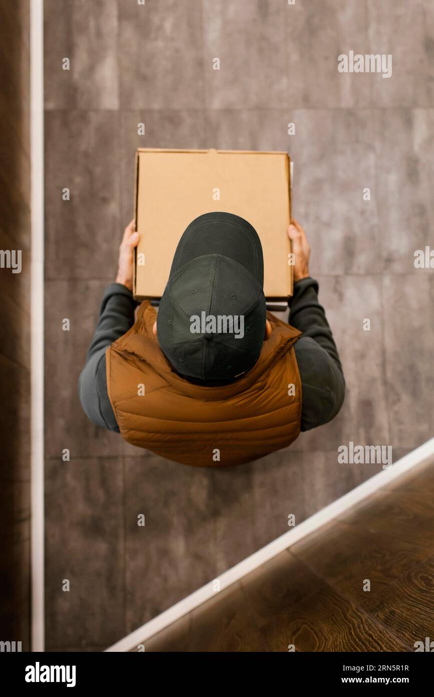 Deliver man holding package Stock Photo - Alamy