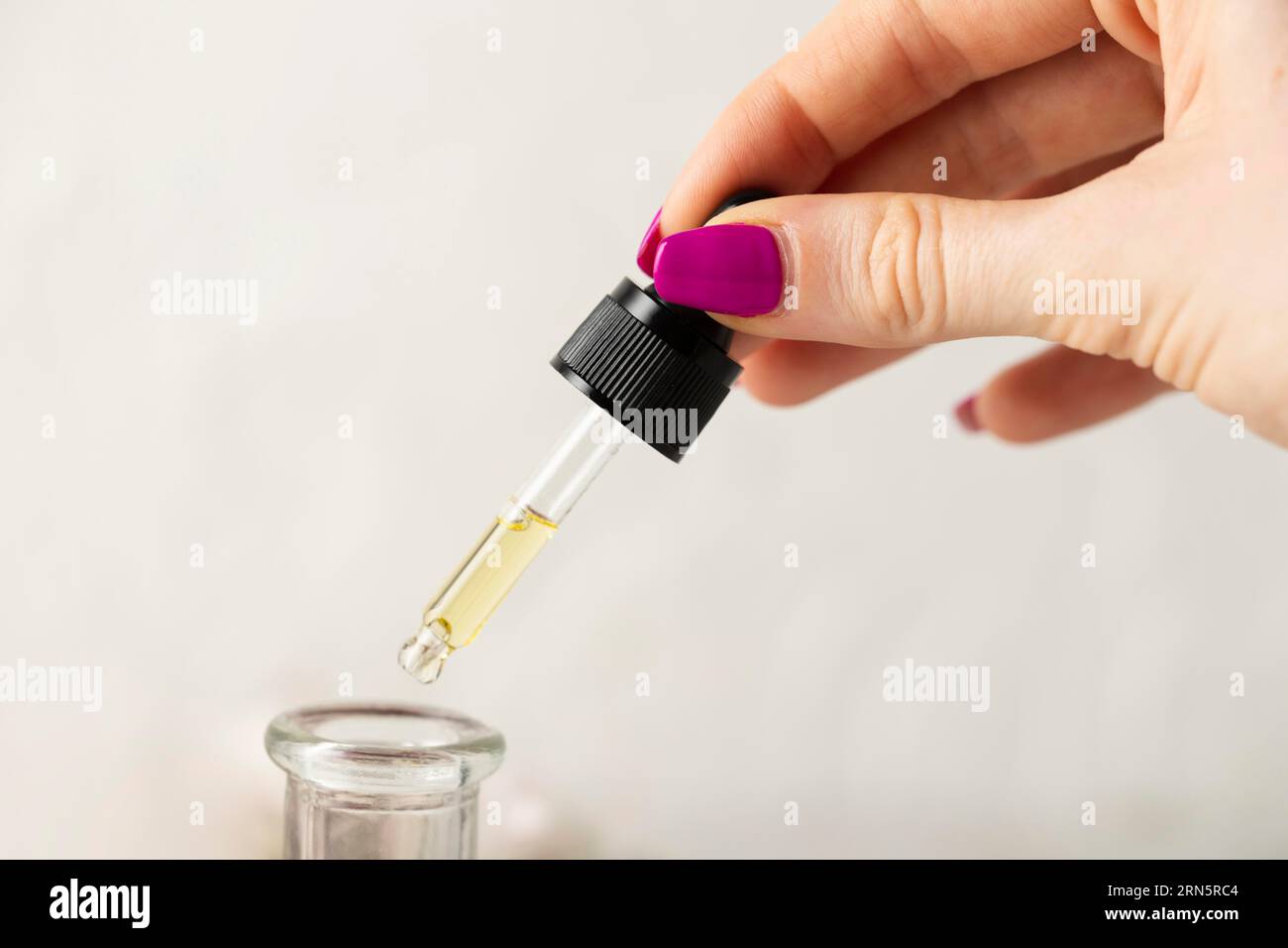 Front view hand using body serum Stock Photo - Alamy
