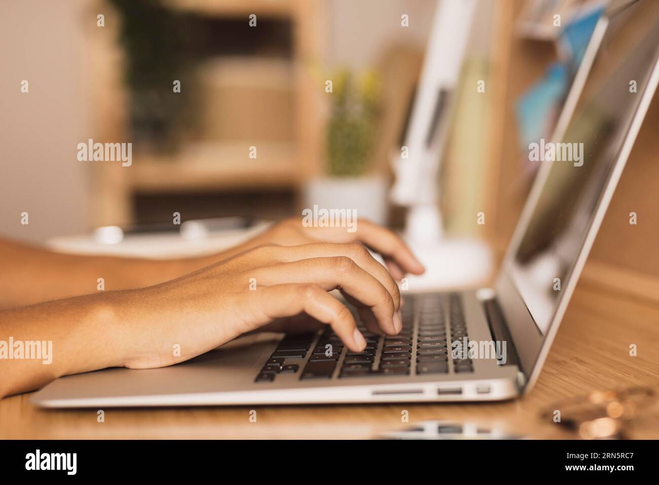 Hands typing laptop lateral view Stock Photo - Alamy