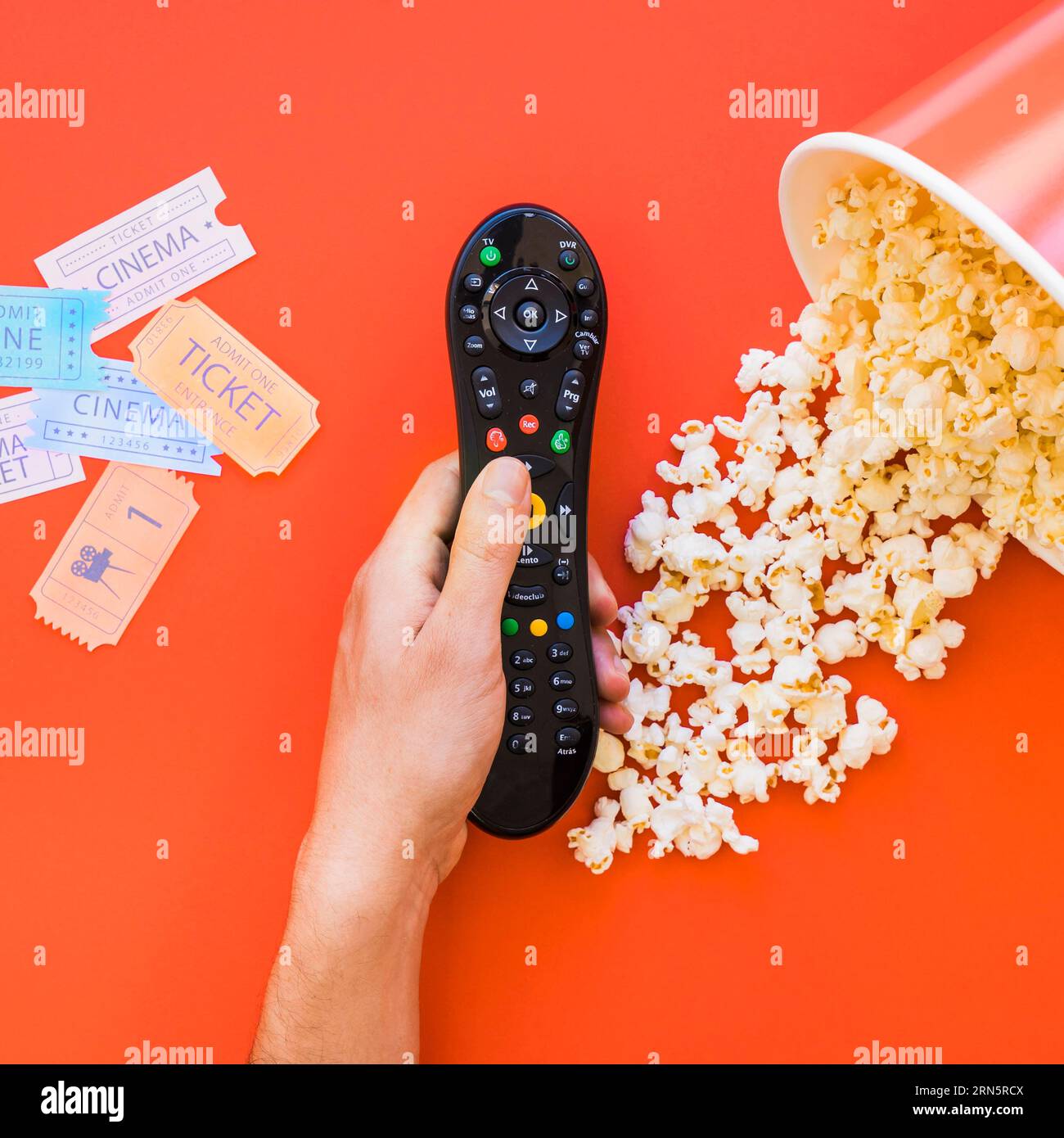 Hand holding remote control popcorn movie tickets Stock Photo - Alamy