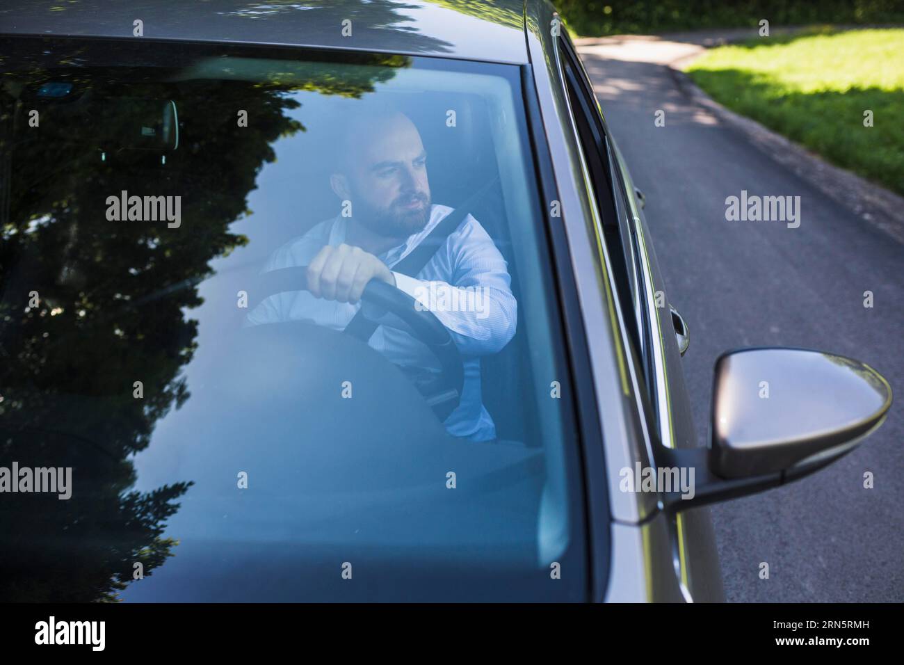 Man sitting inside car seen through windscreen Stock Photo - Alamy