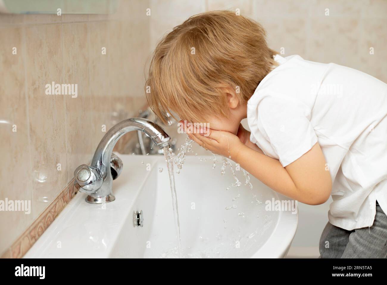 Side view boy washing his face Stock Photo - Alamy