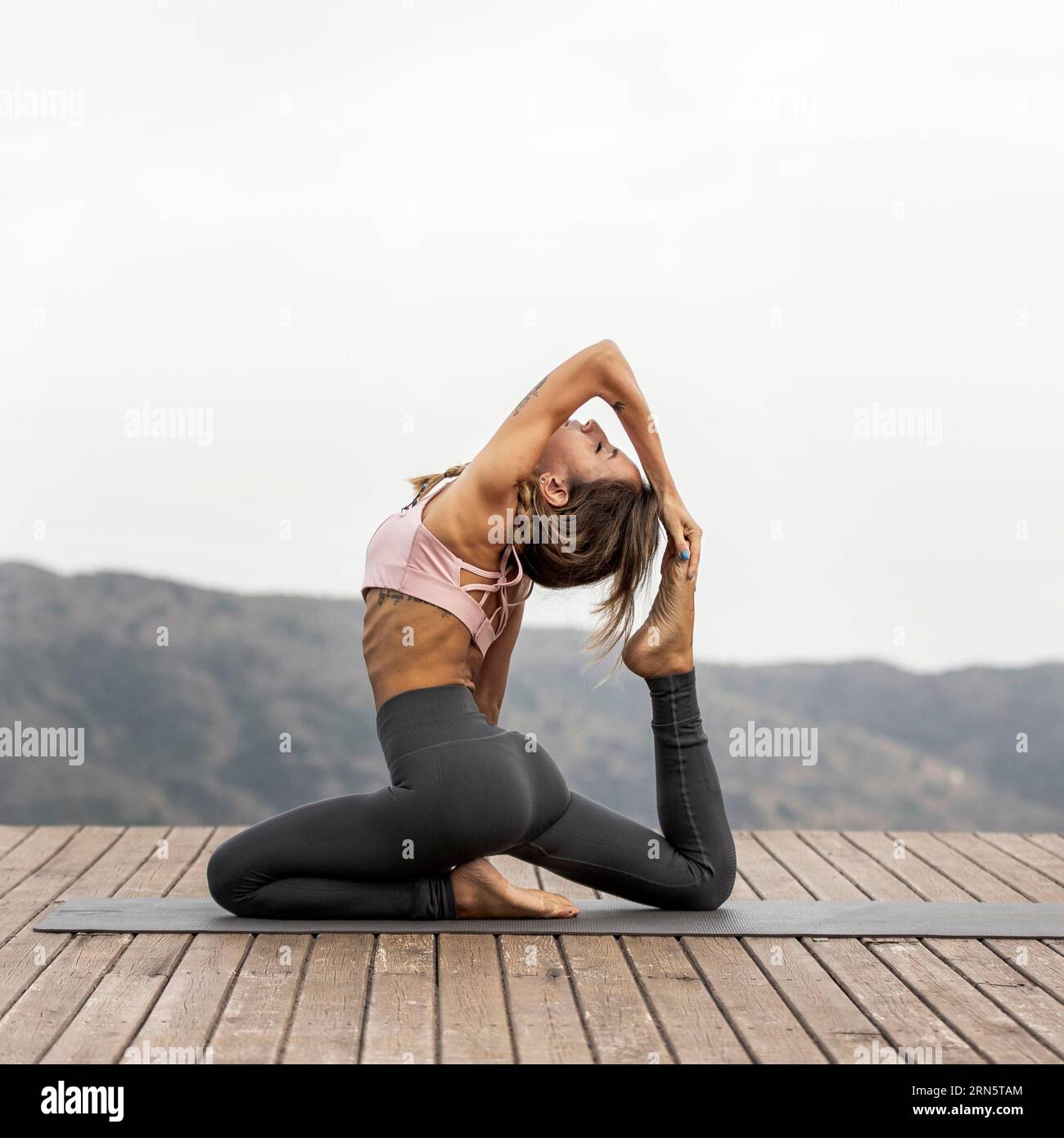 Side view woman doing yoga outdoors Stock Photo - Alamy