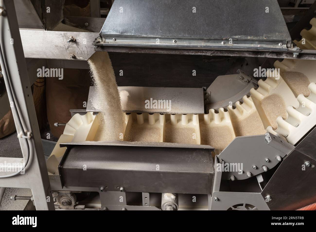 The process of pouring sugar on a belt convoy into the same cells Stock ...