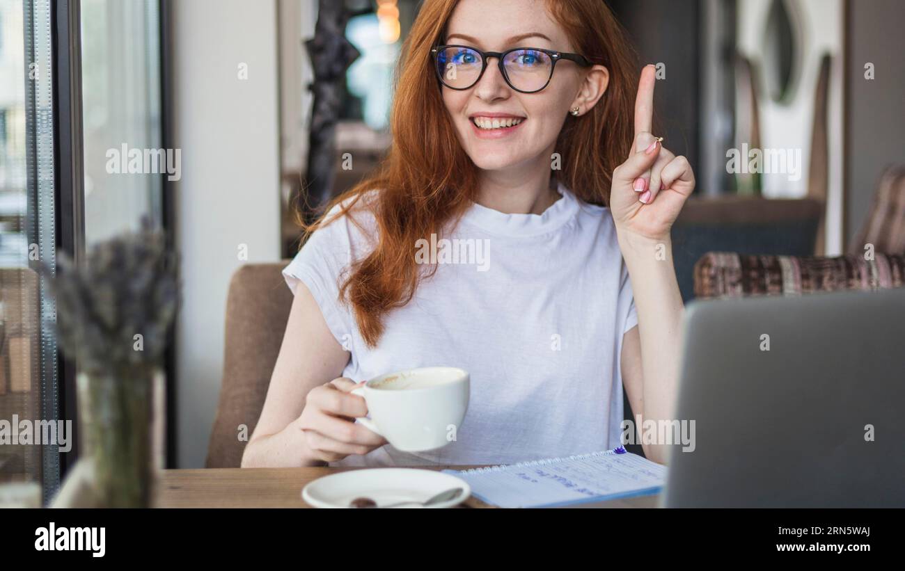 Woman with coffee cup showing pointing finger Stock Photo - Alamy