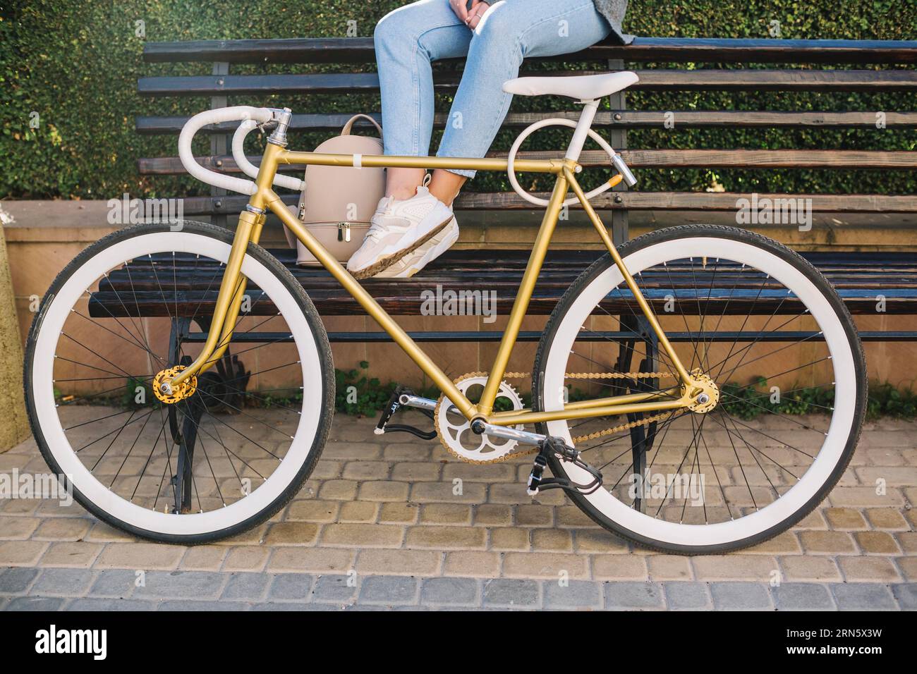 Crop woman sitting bench bicycle Stock Photo - Alamy