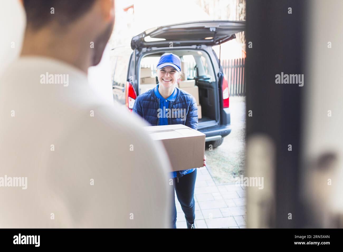 Delivery girl carrying box customer Stock Photo - Alamy