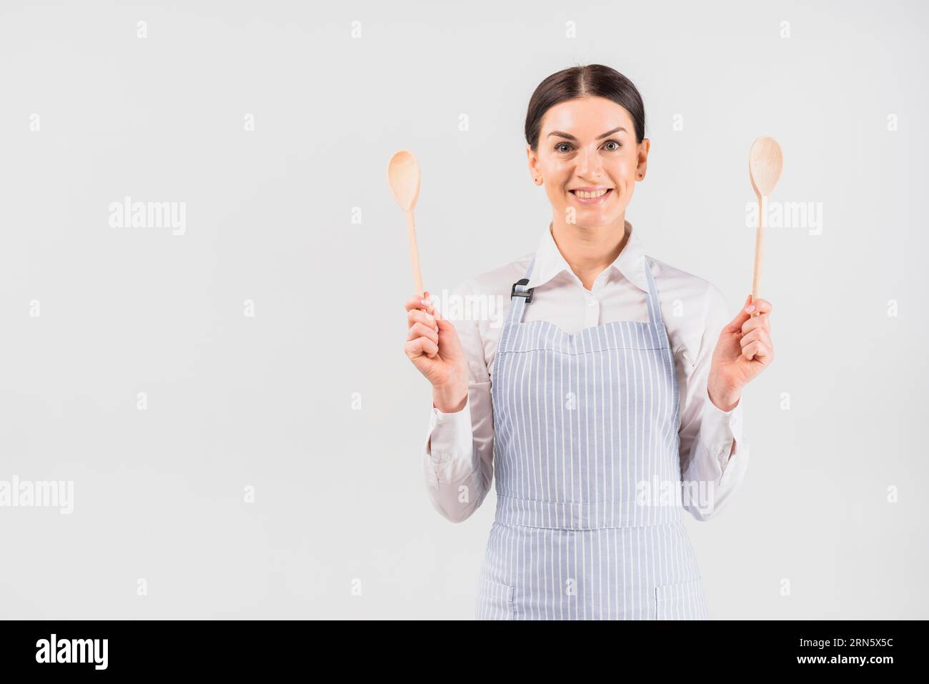 Female apron smiling holding spoons Stock Photo - Alamy