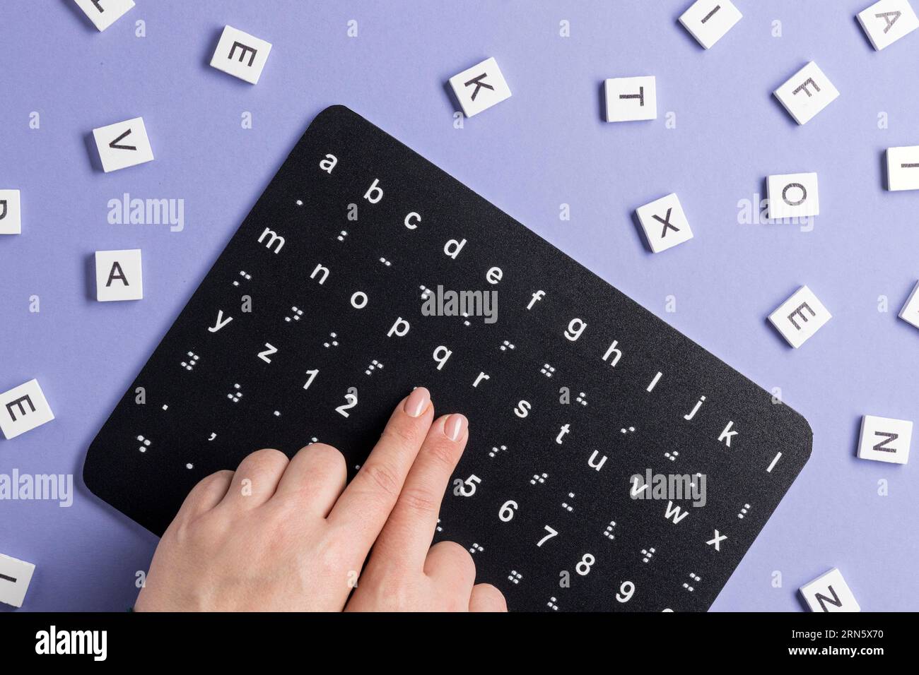 Fingers touching braille alphabet board Stock Photo - Alamy