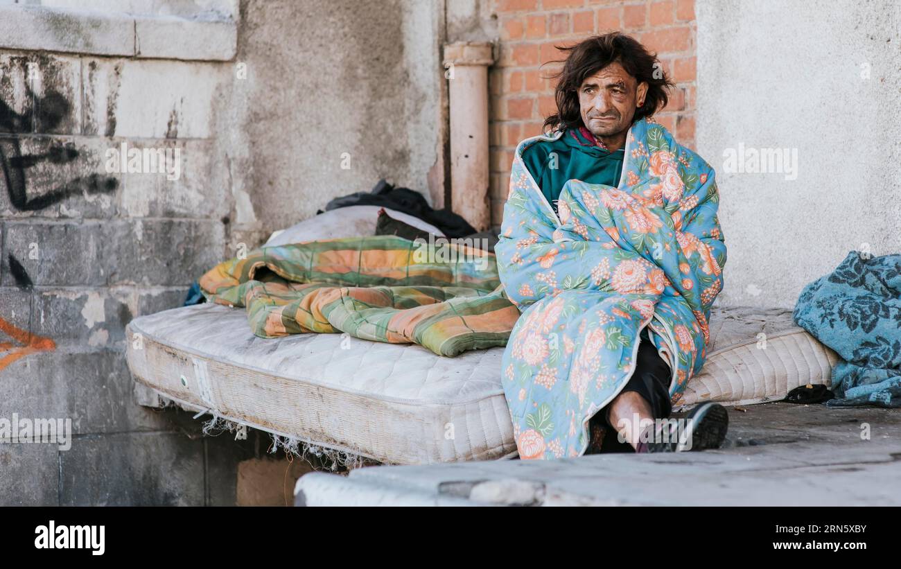 Front view homeless man mattress outside blanket Stock Photo - Alamy
