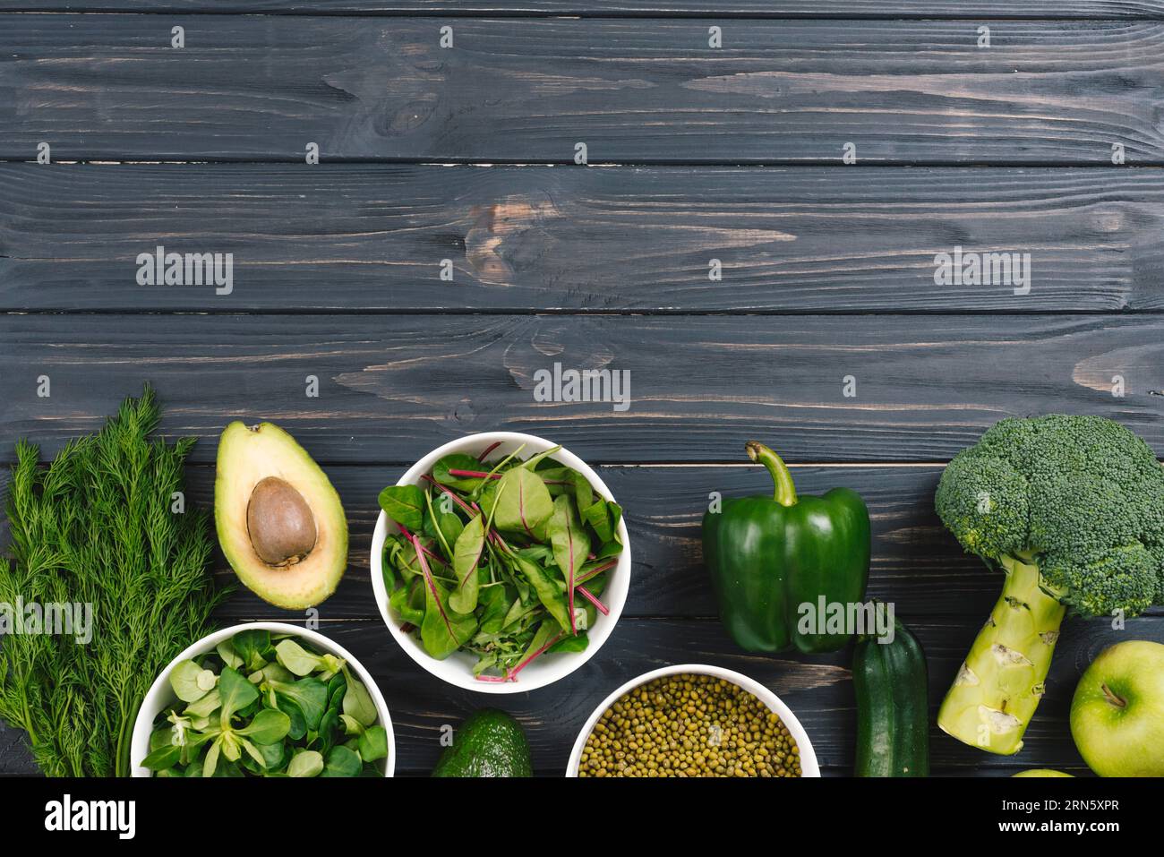 Green fresh vegetables black wooden desk Stock Photo - Alamy