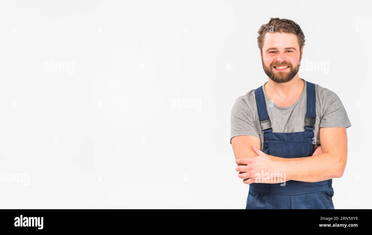 Man overall smiling with crossed arms Stock Photo - Alamy
