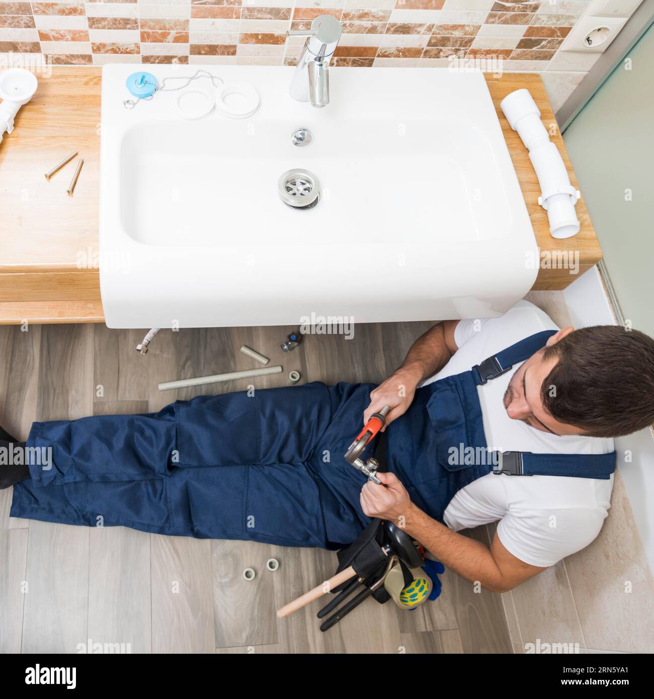 Sanitary technician working with sink Stock Photo - Alamy