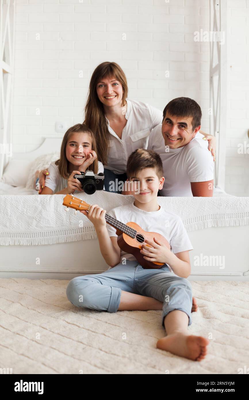 Smiling parent with their children looking camera Stock Photo - Alamy