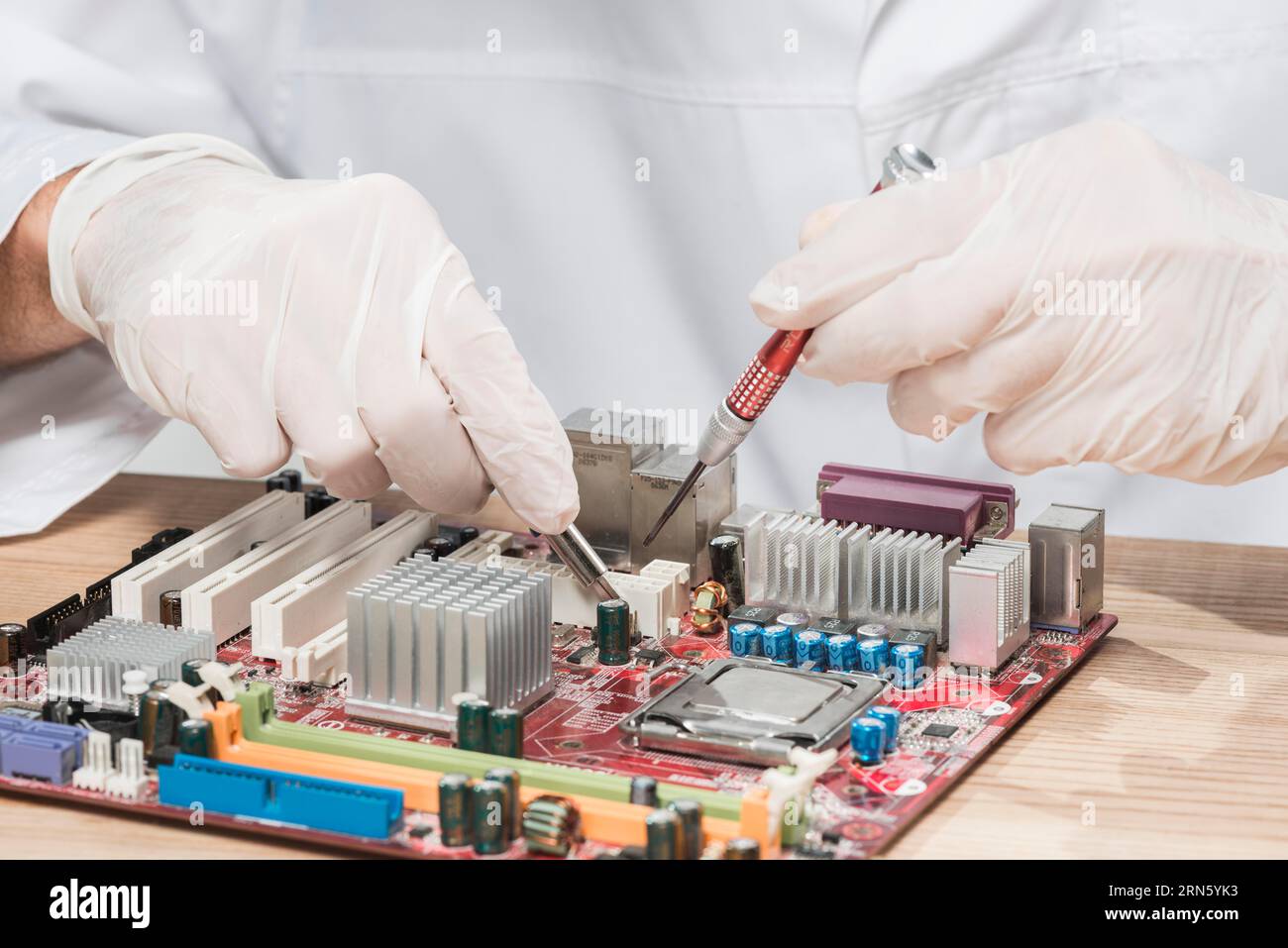 Technician wearing gloves working computer motherboard Stock Photo - Alamy