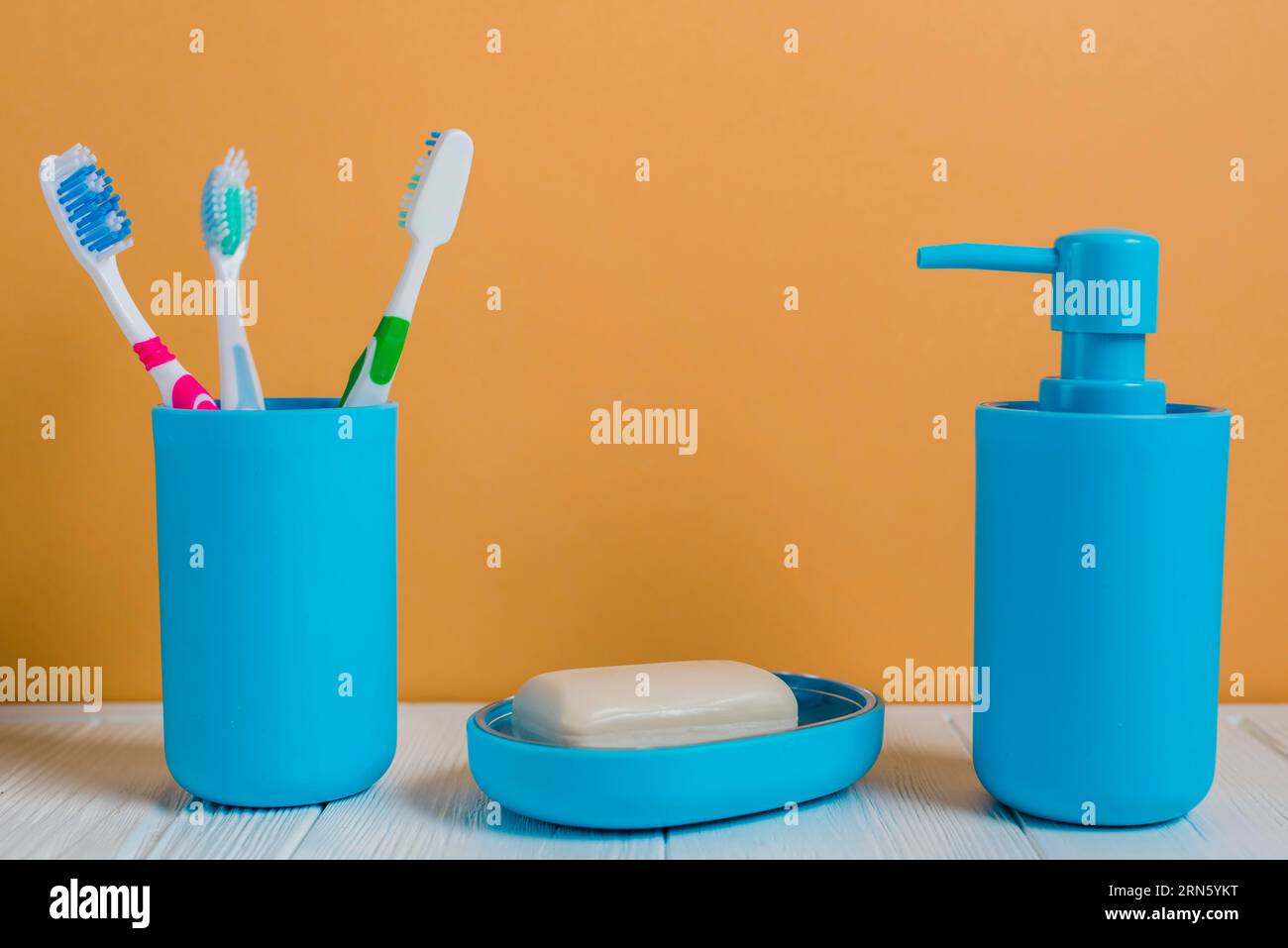 Toothbrushes soap soap dispenser bottle white desk against wall Stock ...