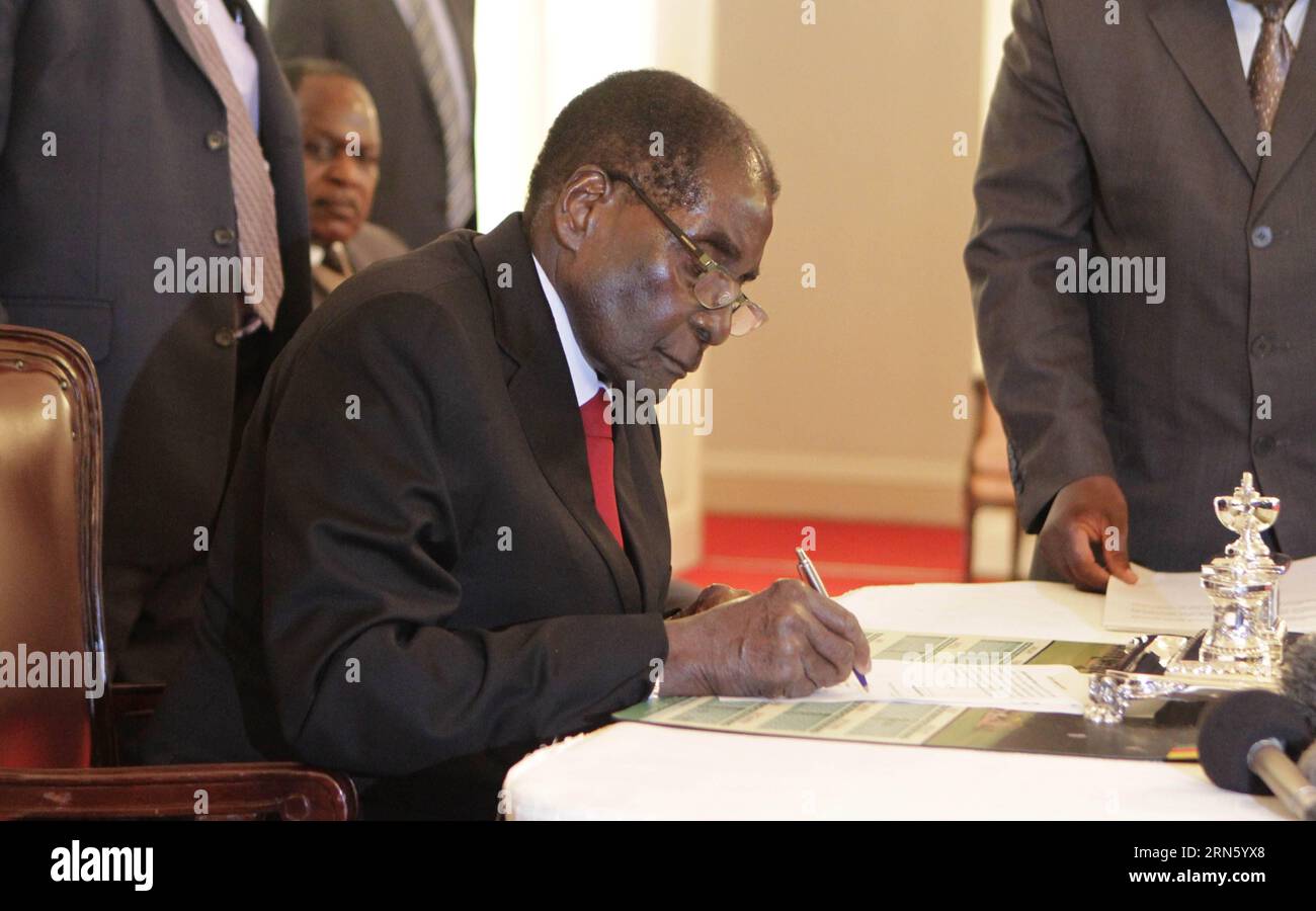 Zimbabwean President Robert Mugabe signs the documents to swear in new ...