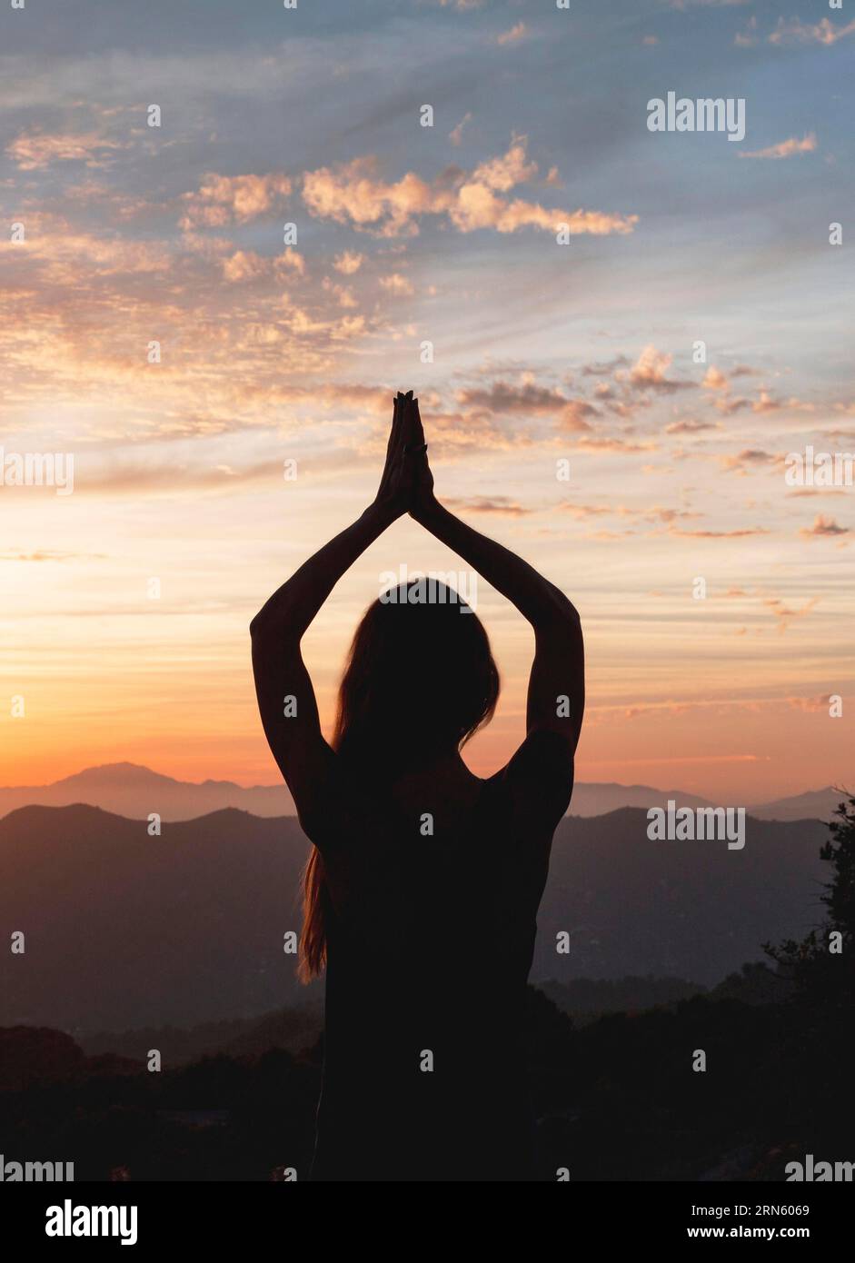 Back view woman yoga pose during sunset Stock Photo - Alamy