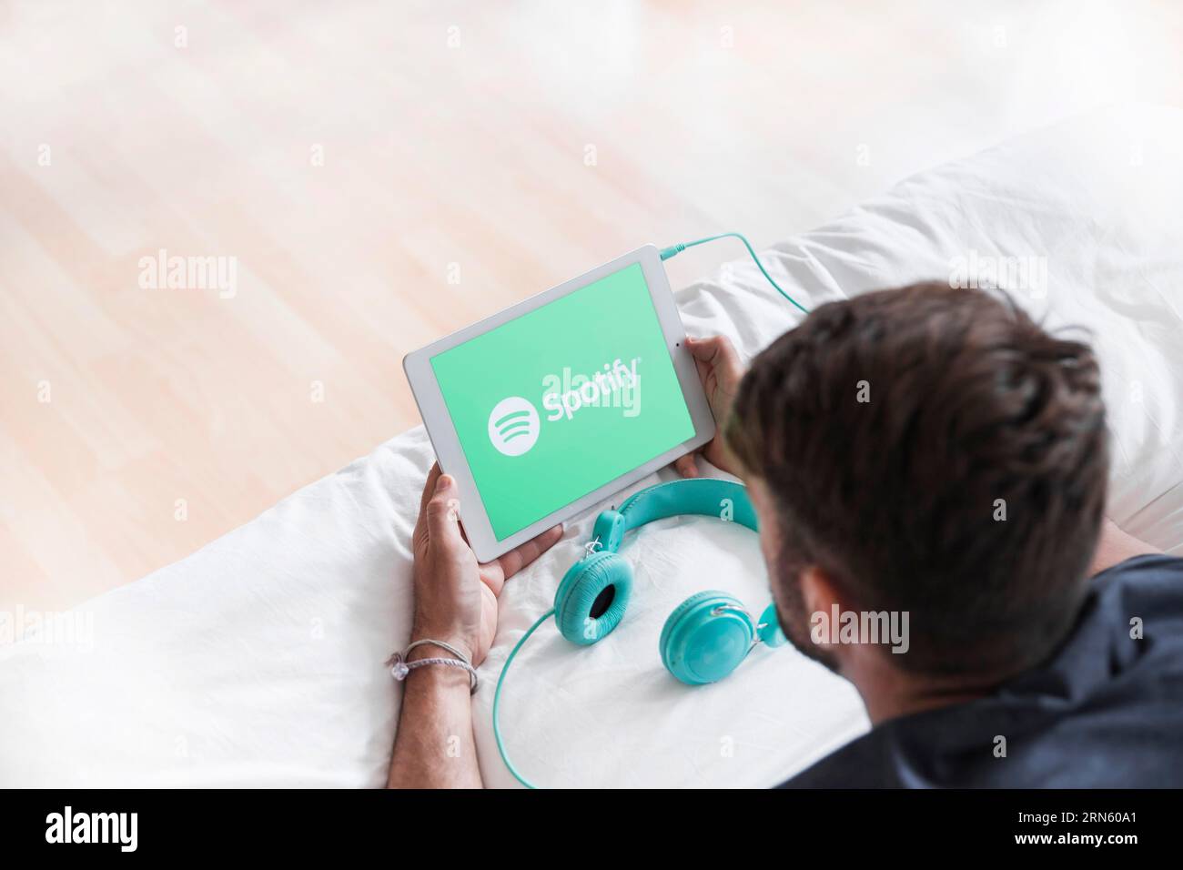 Young man holding modern device with spotify app Stock Photo - Alamy