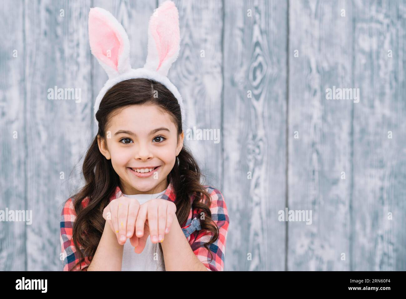 Close up girl posing like bunny against wooden gray background Stock ...