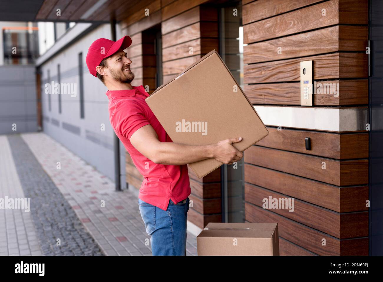 Delivery man carrying package Stock Photo - Alamy