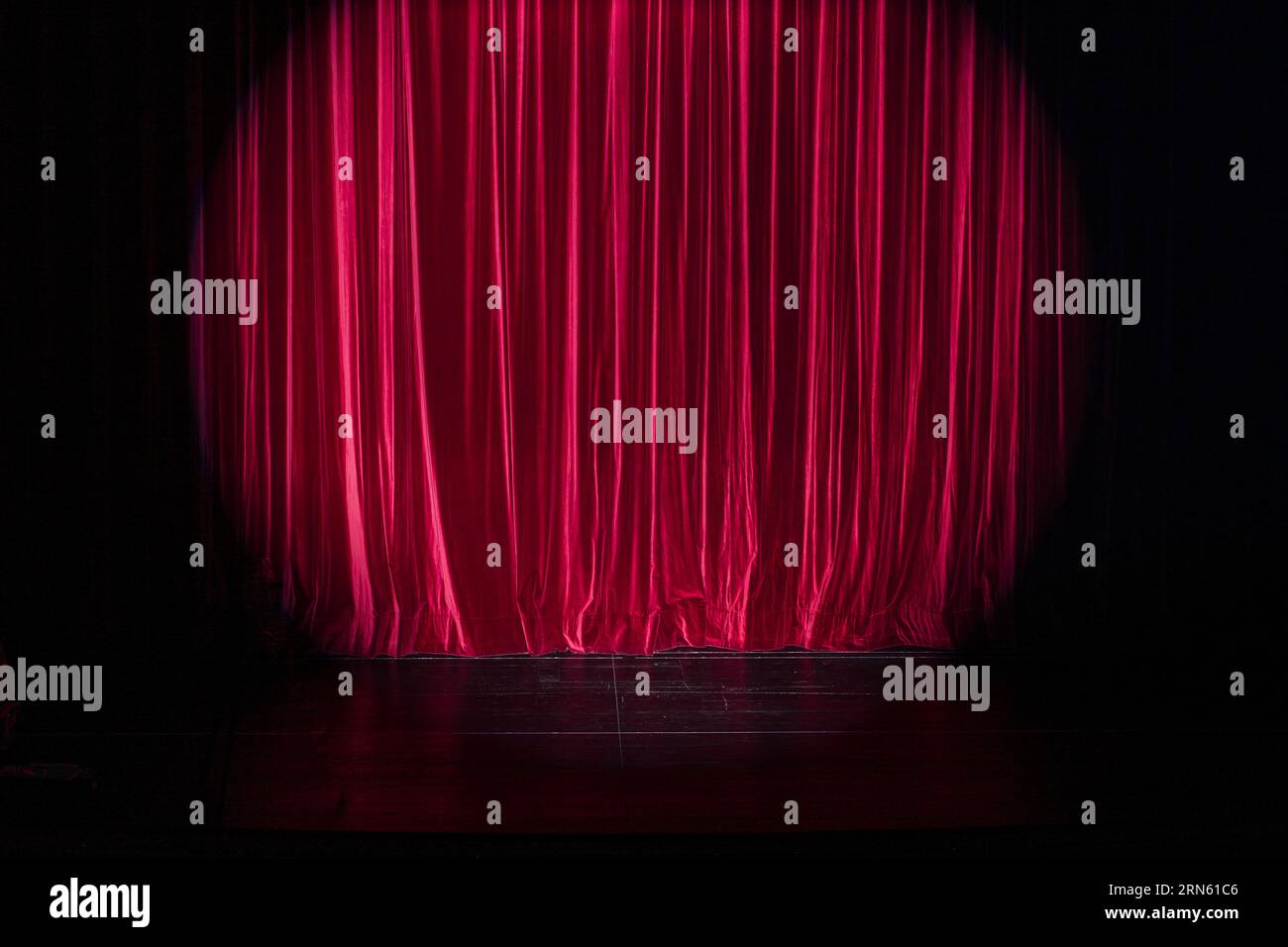 Empty stage with light spot on red curtain Stock Photo - Alamy