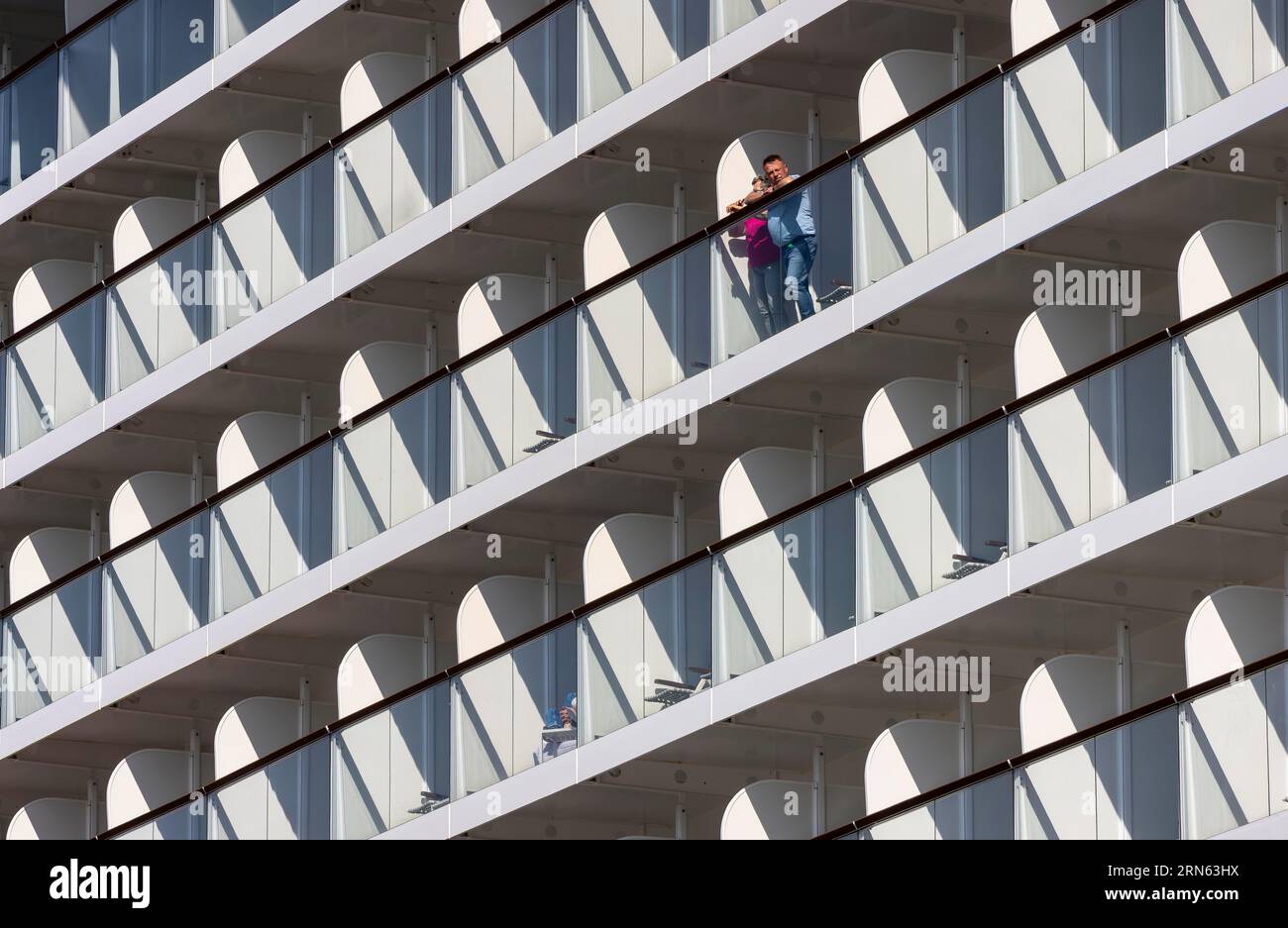 Detail of a passenger ship with windows and balconies with a couple on ...