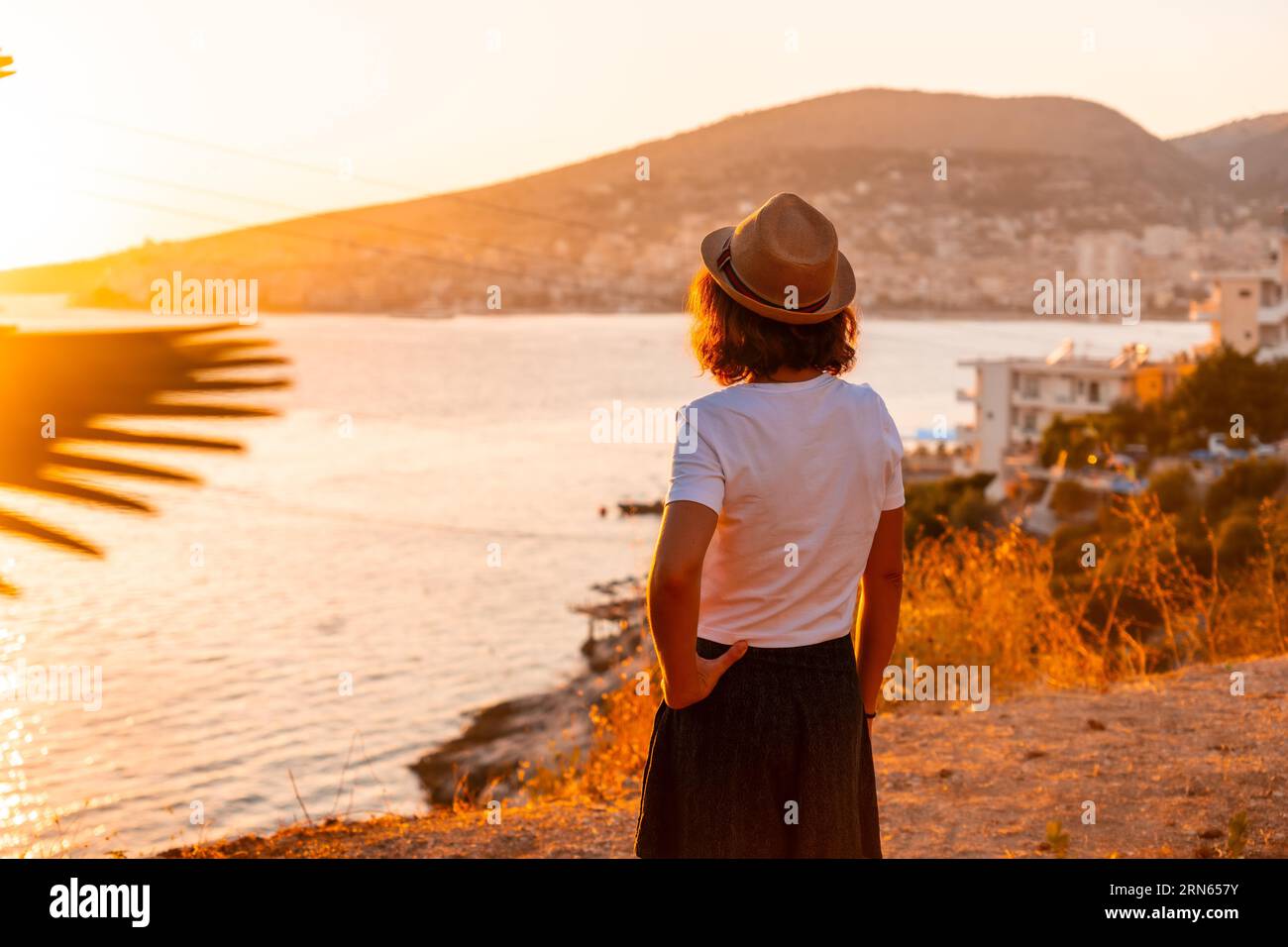 Tourist woman at Sarande or Saranda sunset in Albanian riviera enjoying ...