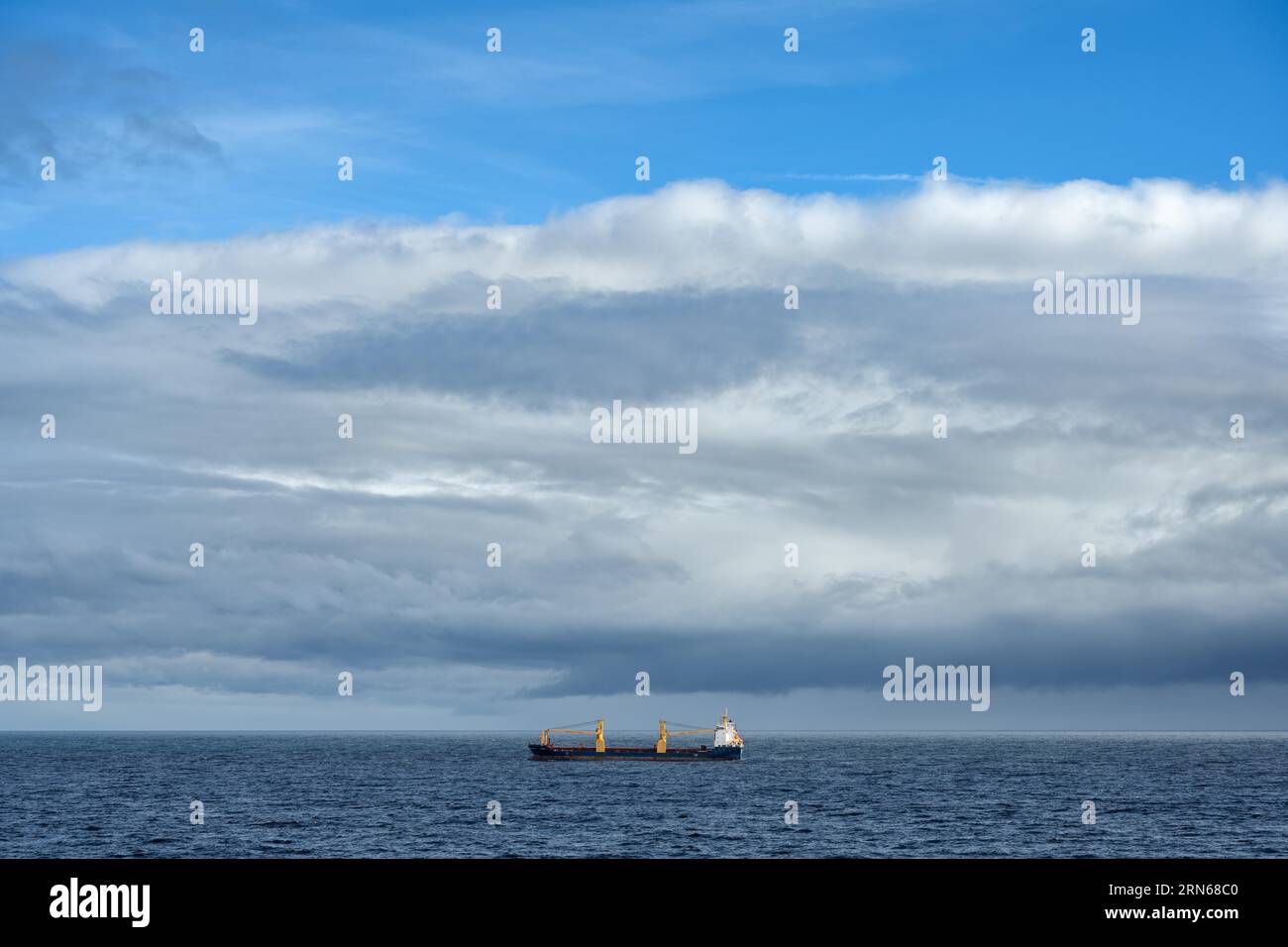 Cargo ship on the North Sea. behind it moving rain clouds, England ...