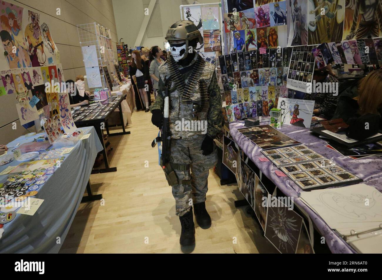 A cosplayer walks along the comic poster booths during the Anime ...