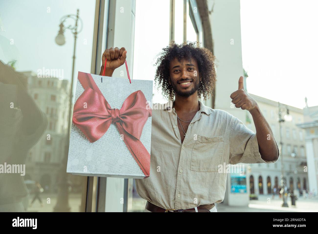 A man goes shopping and is happy, he gives the thumbs up with the ...