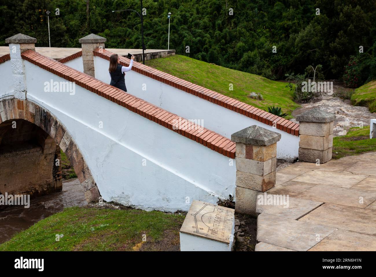 Female tourist taking selfies at the famous historic Bridge of Boyaca ...