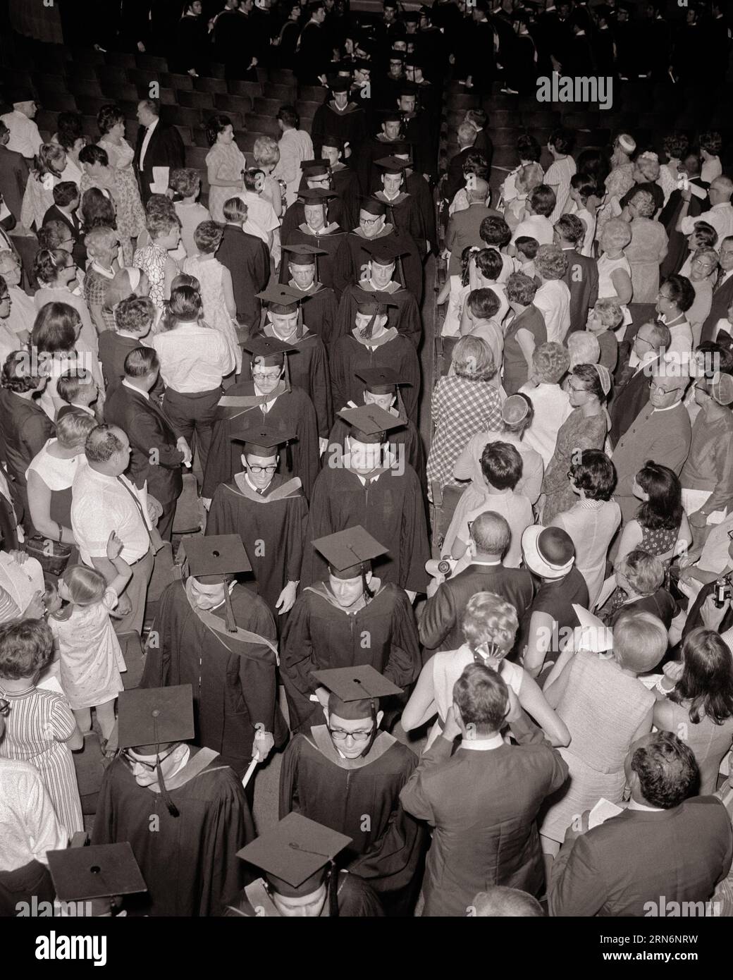 1970s COLLEGE GRADUATION CLASS WALKING OUT OF AUDITORIUM IN AISLE ...