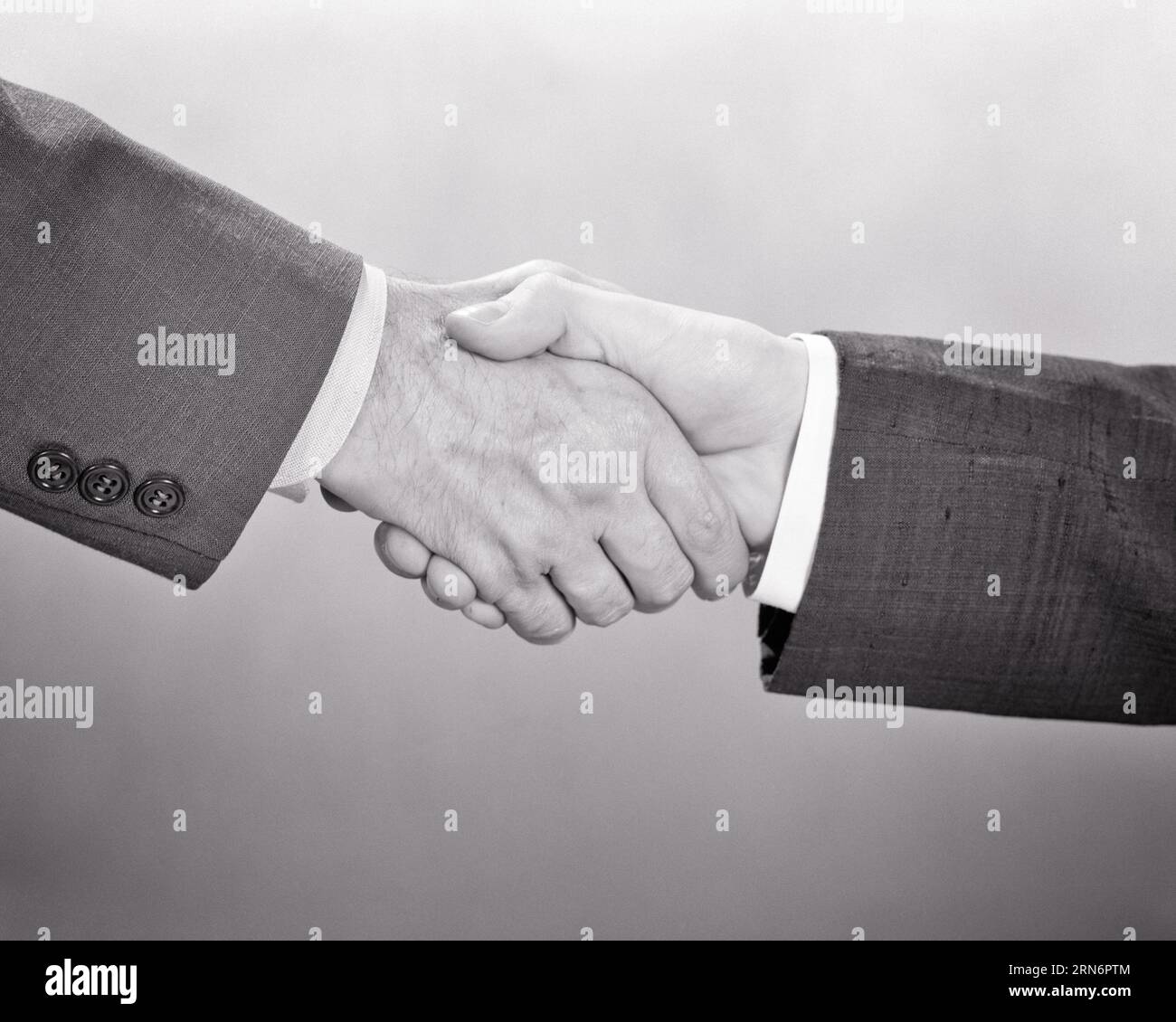 1950s 1960s SHAKING HANDS TWO CAUCASIAN BUSINESSMEN SHIRT AND JACKET ...