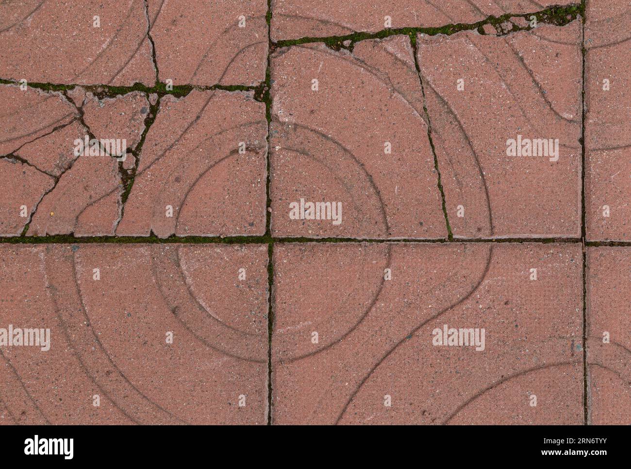 Close-up of broken and weathered red square paving stones or blocks ...
