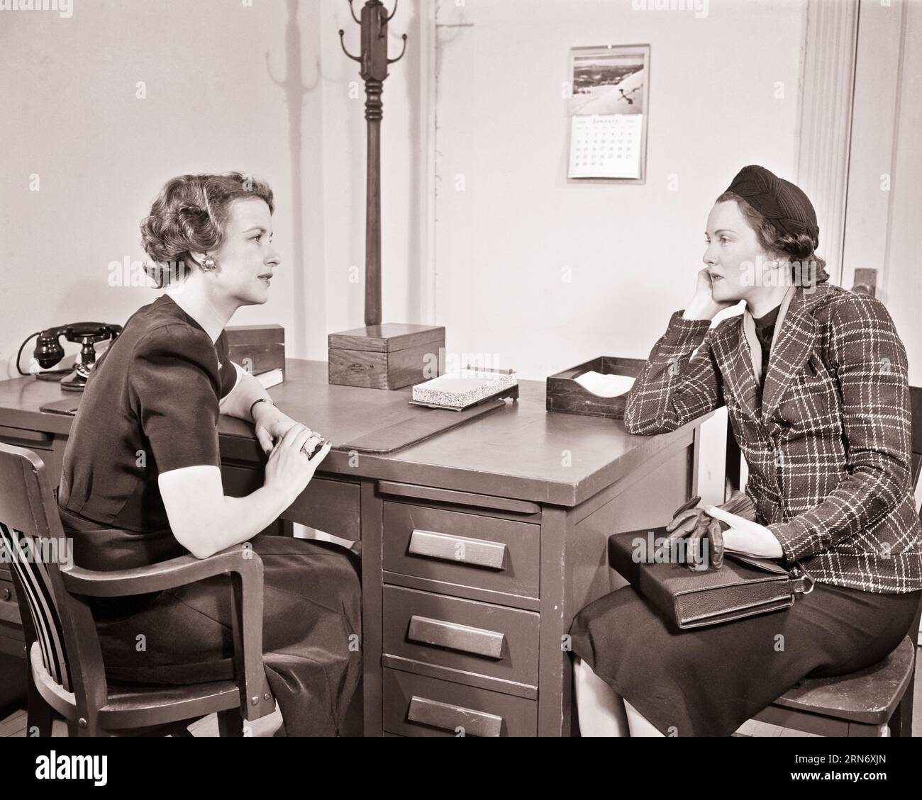 1940s WOMAN SEATED AT DESK CONDUCTING A JOB INTERVIEW INTERVIEWING ...