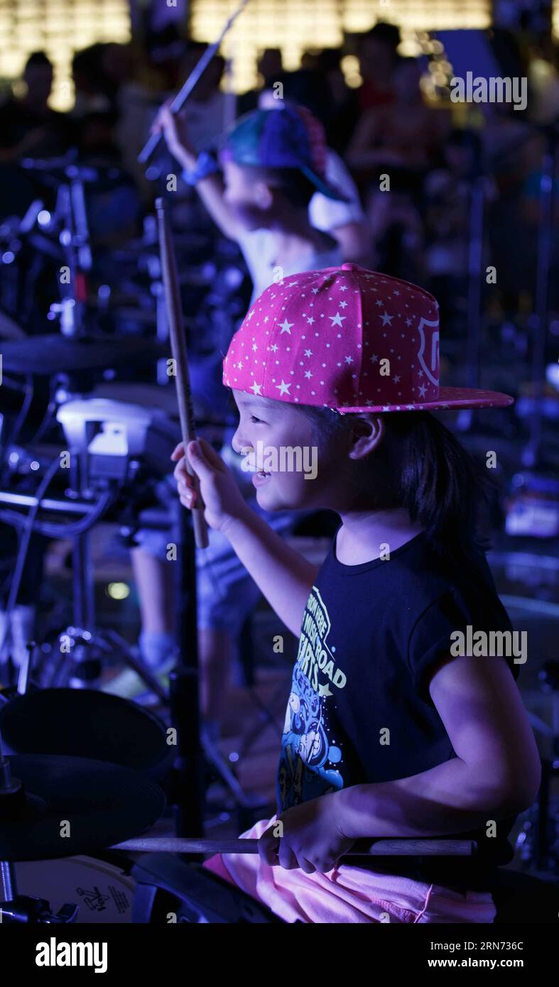 A child plays a drum set during his performance with a band at a ...