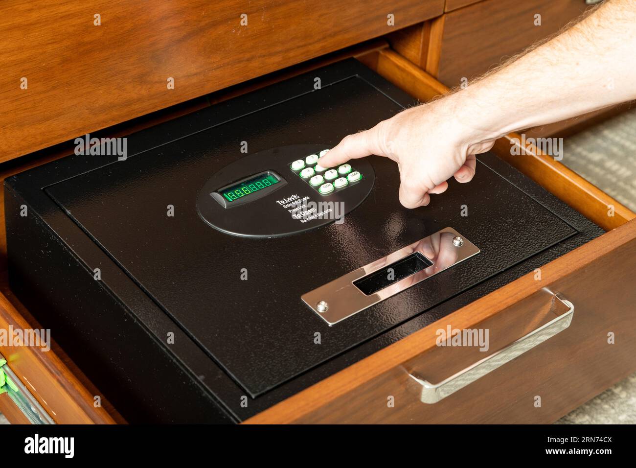 Hand opening safe in hotel room to store valuables Stock Photo - Alamy