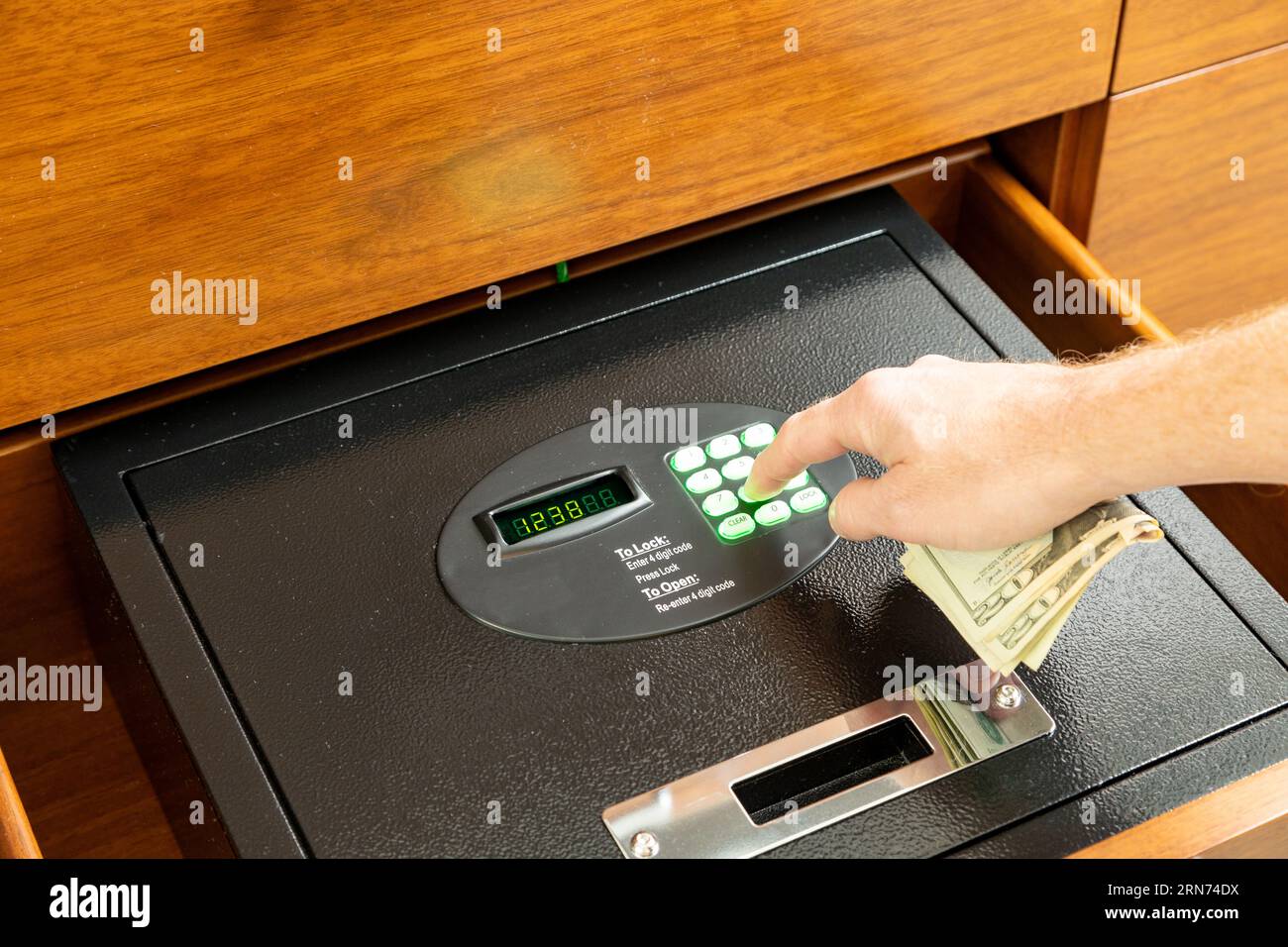 Hand opening safe in hotel room to store valuables Stock Photo - Alamy
