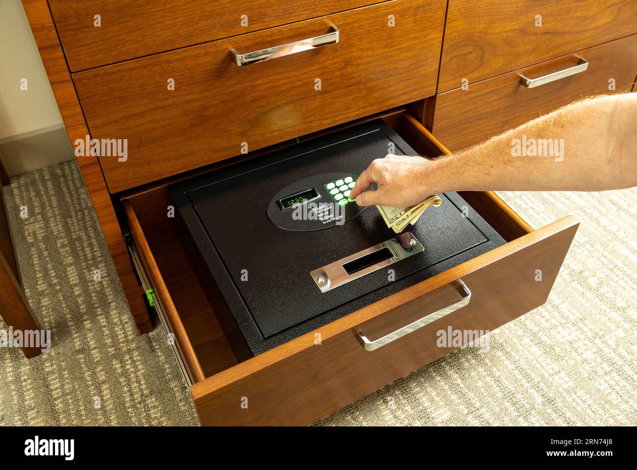Hand opening safe in hotel room to store valuables Stock Photo - Alamy