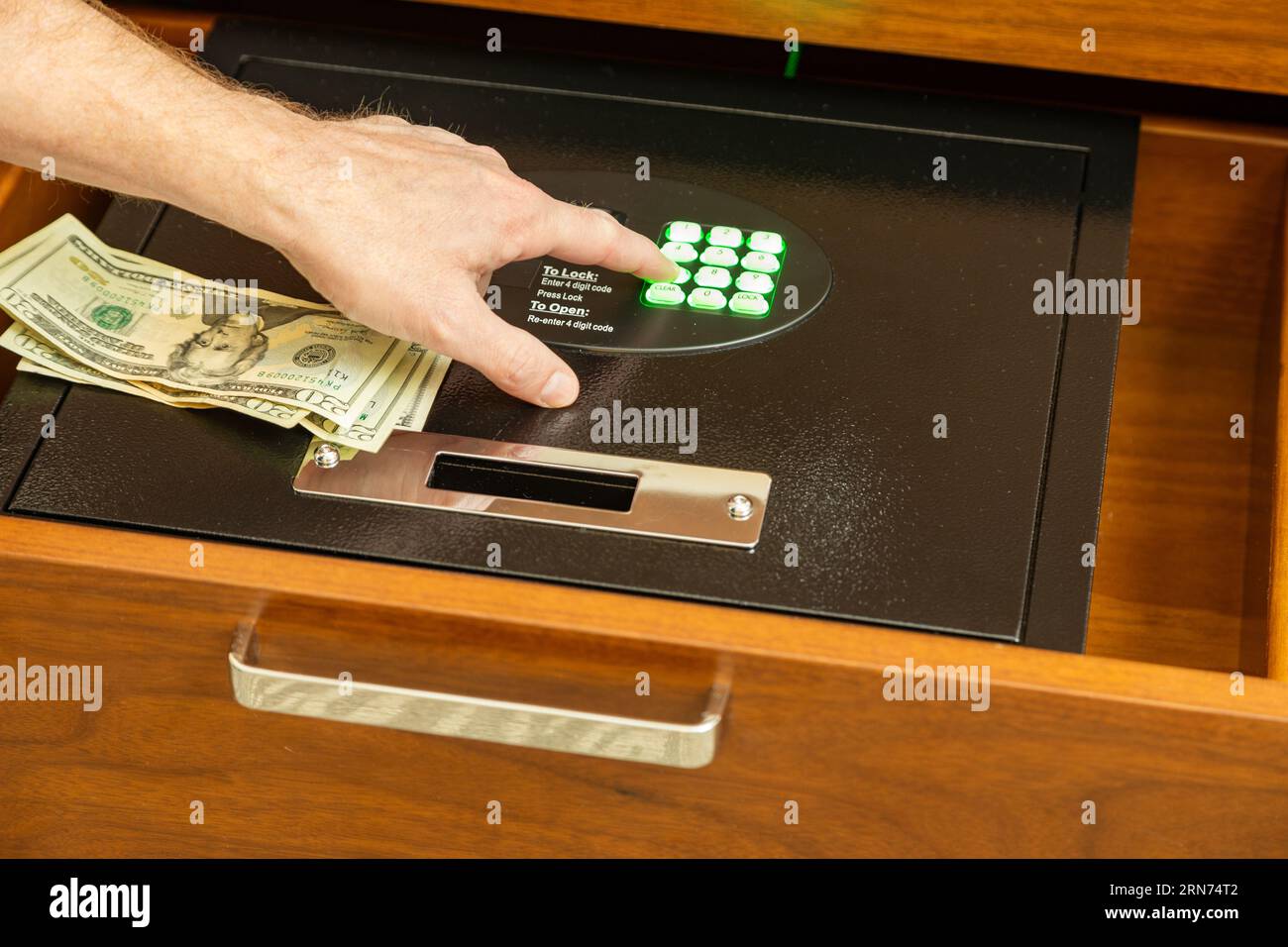 Hand opening safe in hotel room to store valuables Stock Photo - Alamy