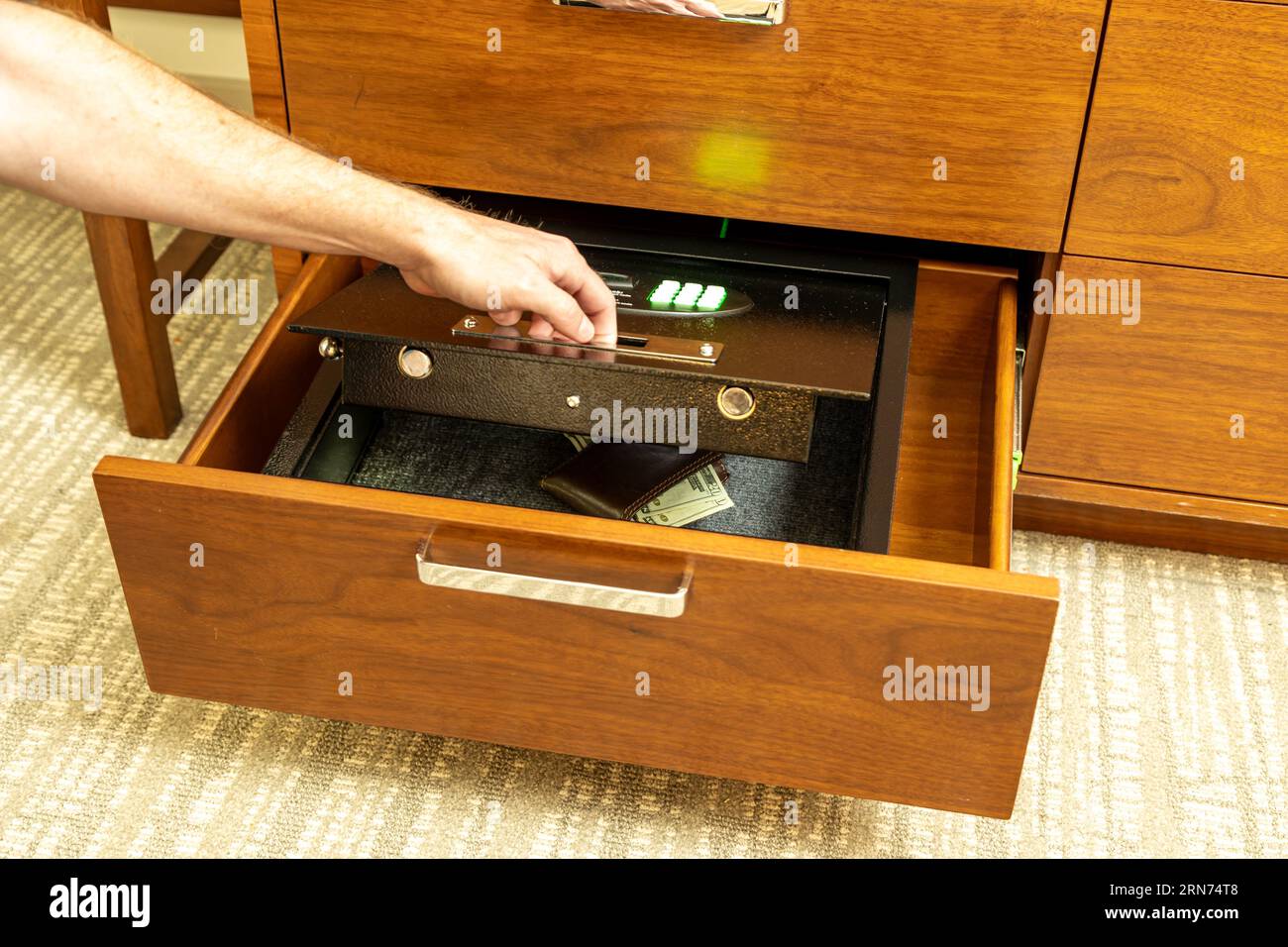 Hand opening safe in hotel room to store valuables Stock Photo - Alamy