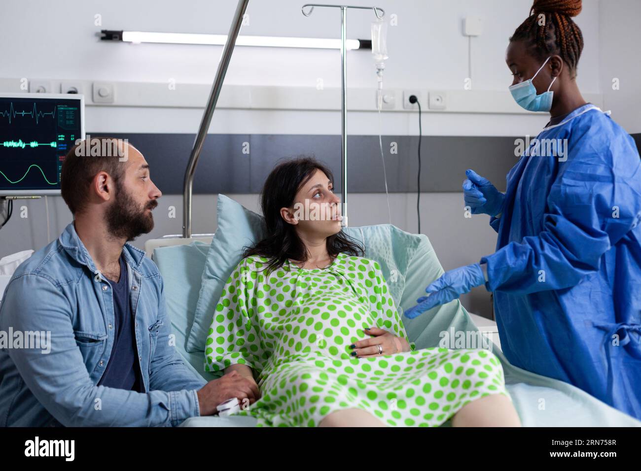 African american surgeron giving medical support to pregnant woman ...